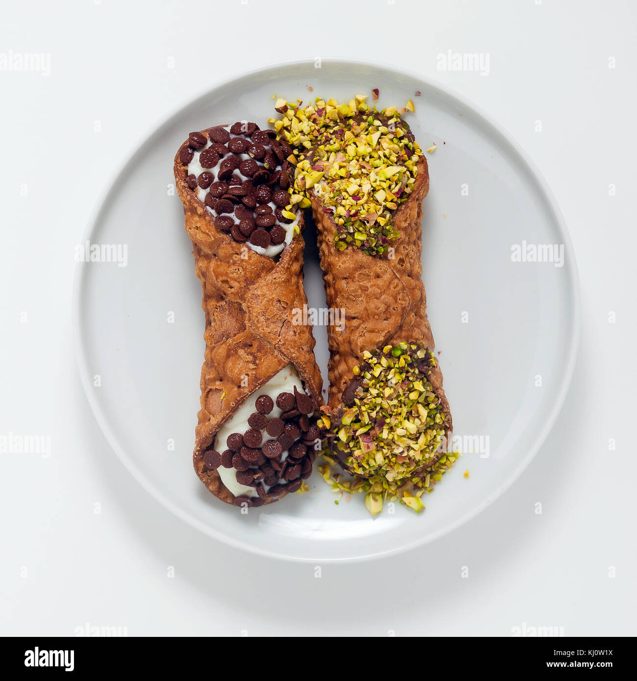Cannoli with ricotta, chocolate and pistachios. Italian pastries of the ...