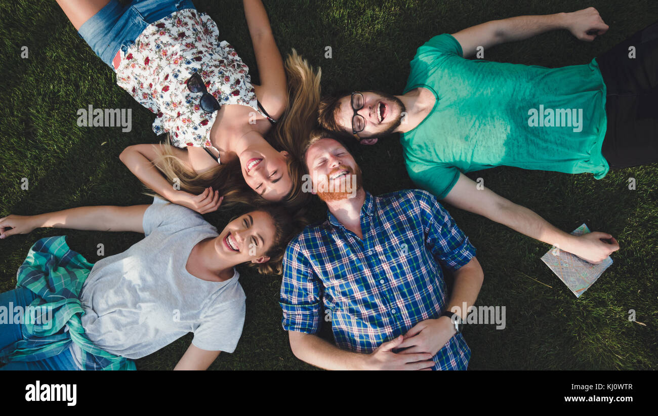 Happy joyful students lying in grass Stock Photo - Alamy