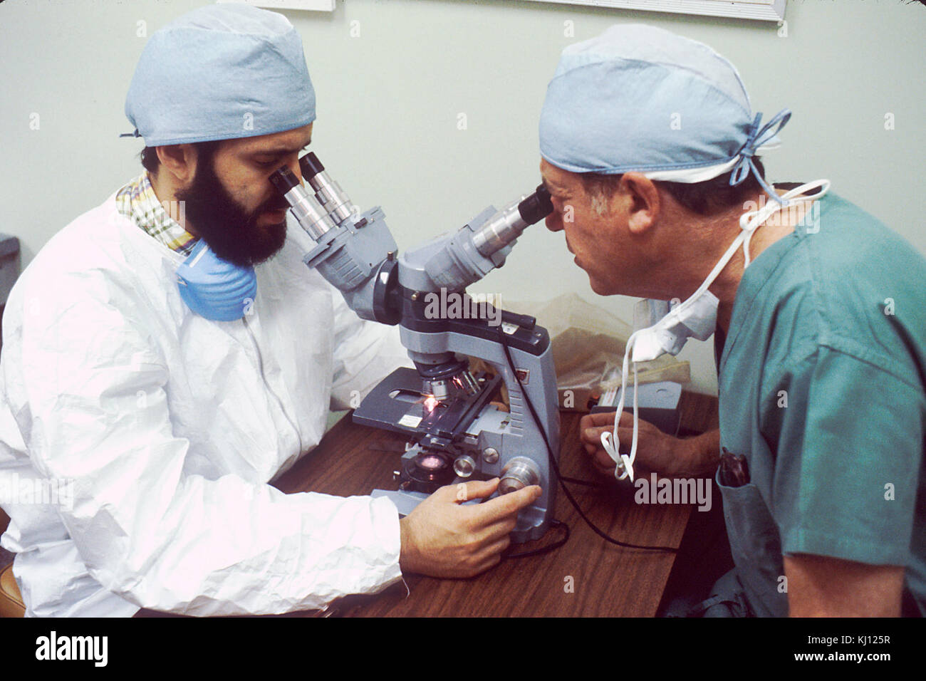 Pathologists looking into microscopes (1 Stock Photo - Alamy