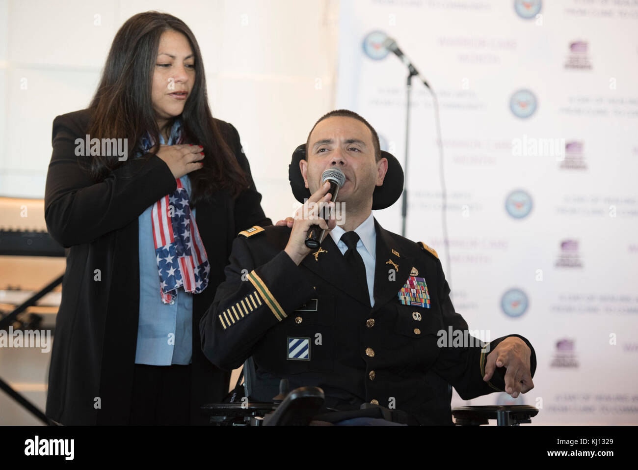 Army Capt. Luis Avila sings the National Anthem as his wife and ...