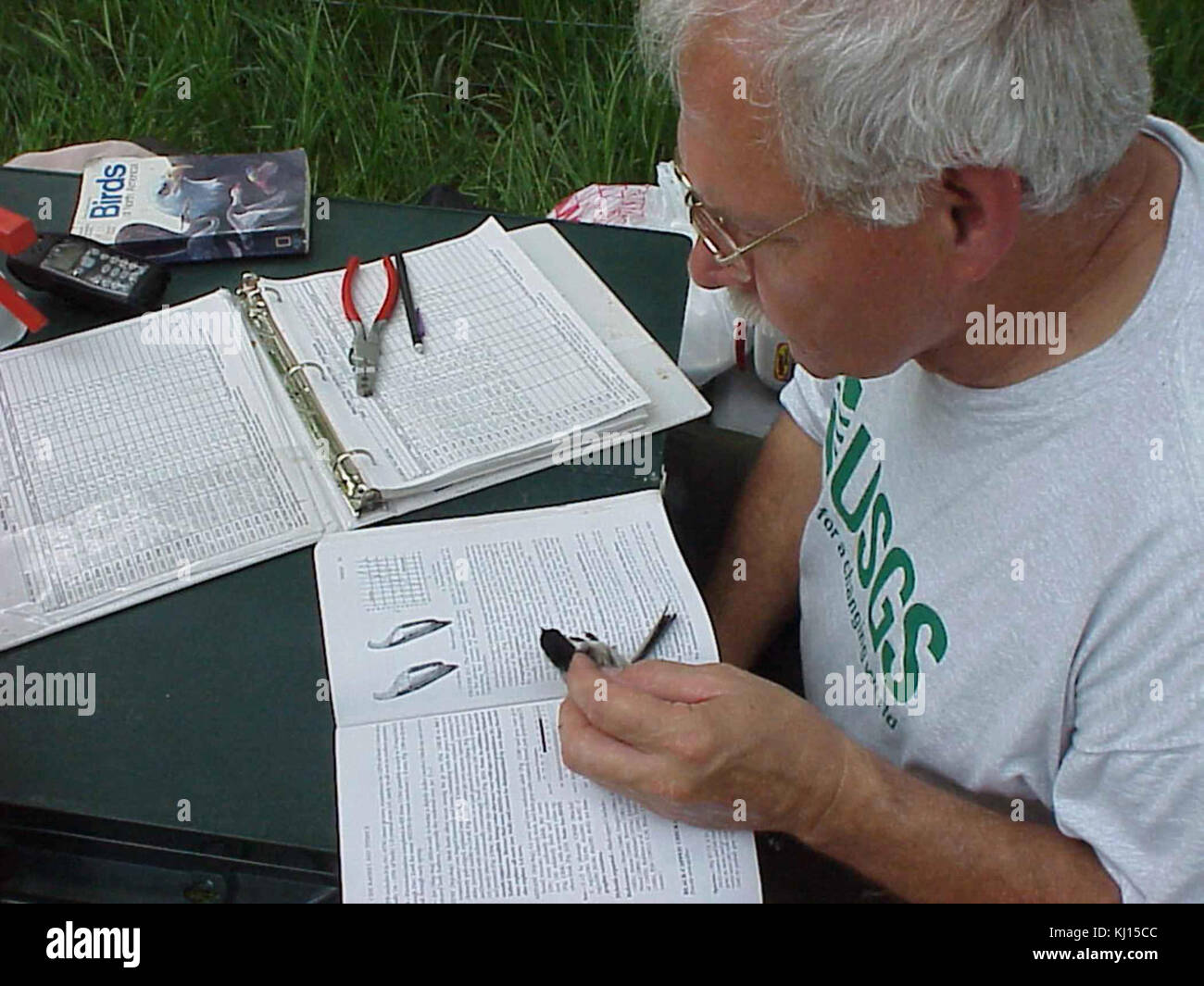 Man reading and writing at table Stock Photo - Alamy