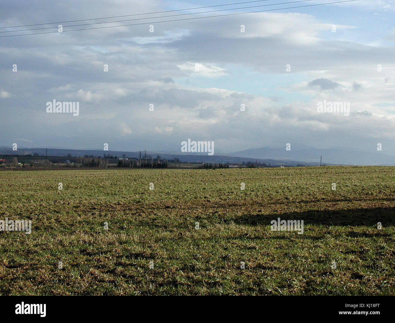 This image features a wide open field under the sky, capturing the ...