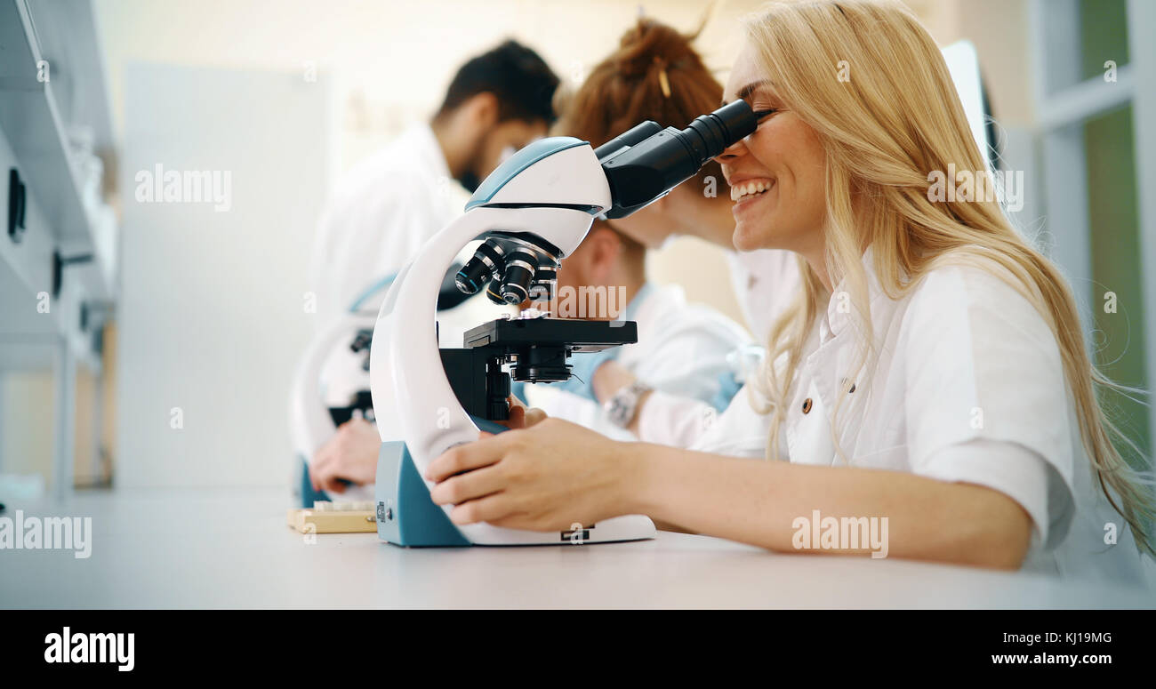Young scientist looking through microscope in laboratory Stock Photo ...
