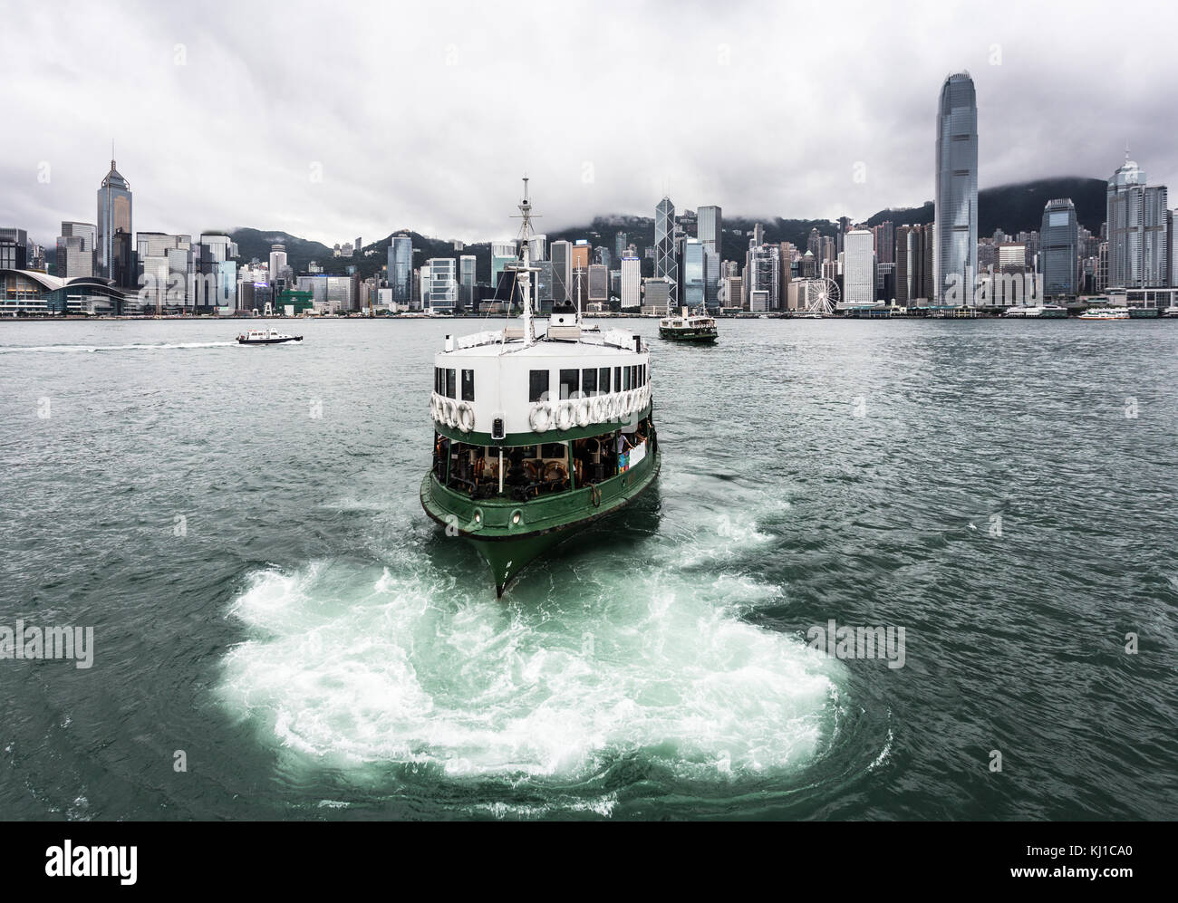 Star ferry on a cloudy sky with the famous Hong Kong island skyline ...