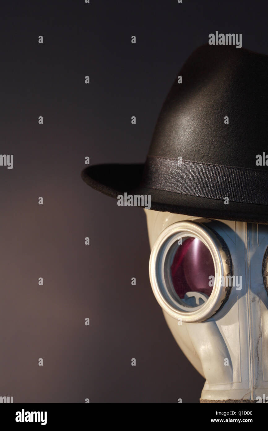 Gas mask with a felt hat closeup on dark background Stock Photo - Alamy