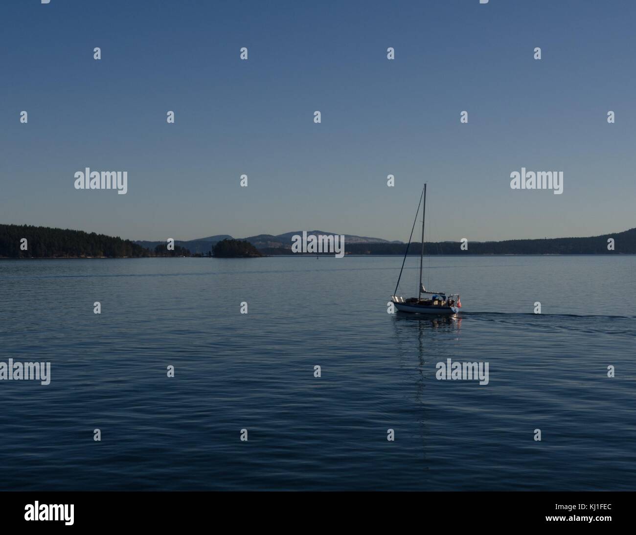 A sloop sailboat under motorized power on very calm water in the Gulf ...