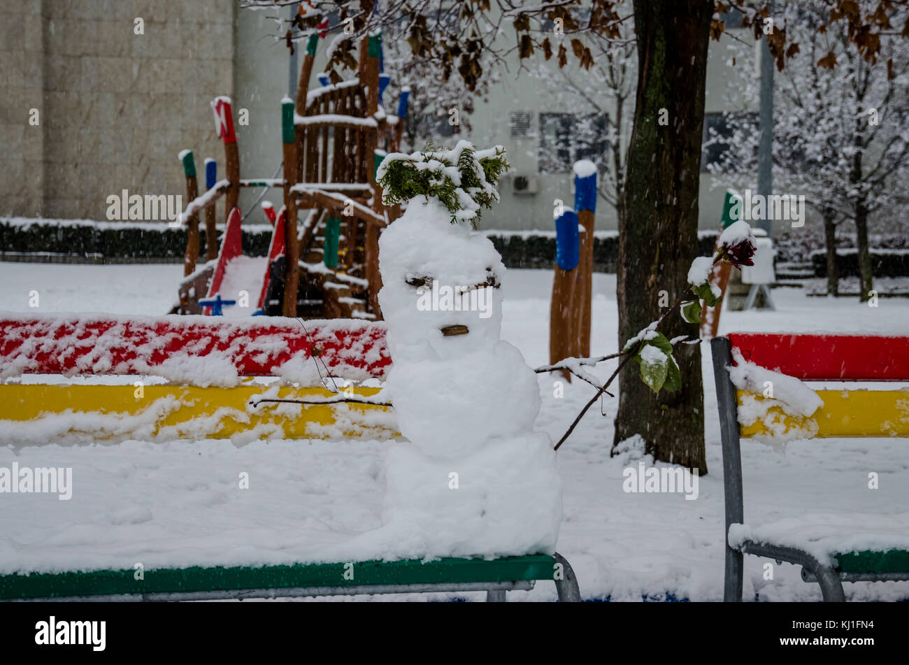 happy snowman figure in colorful children playground covered by snow in ...