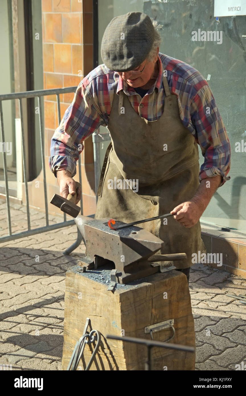 Live demonstration of an old blacksmith on a Provencal market. Chesnut ...