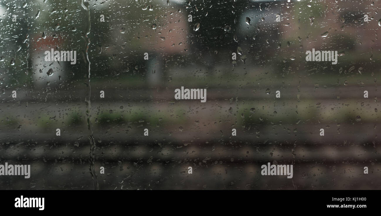Drops of rain at a window with blurred rails in background Stock Photo ...