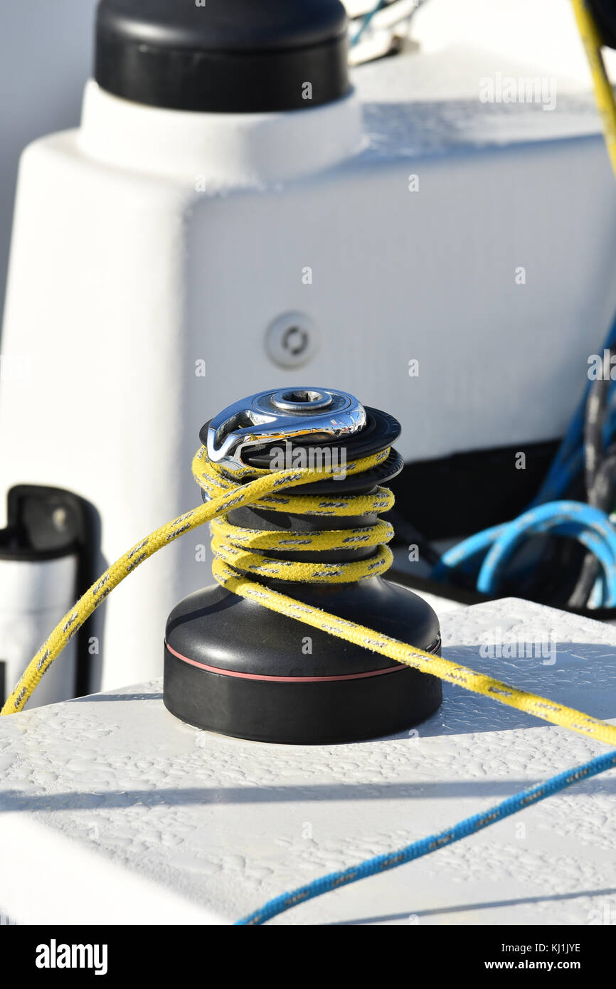 Details of yellow genoa sheet secured on self-tailing winch on sailing ...