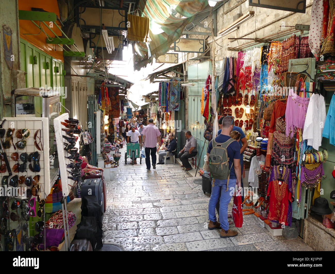 Tourists buying souvenirs in the Arab Market, Jerusalem. They walk over ...