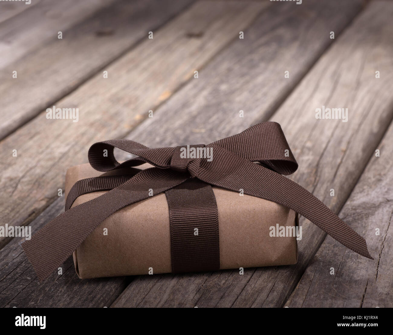 Present wrapped in ribbon and bow on old wood boards Stock Photo - Alamy