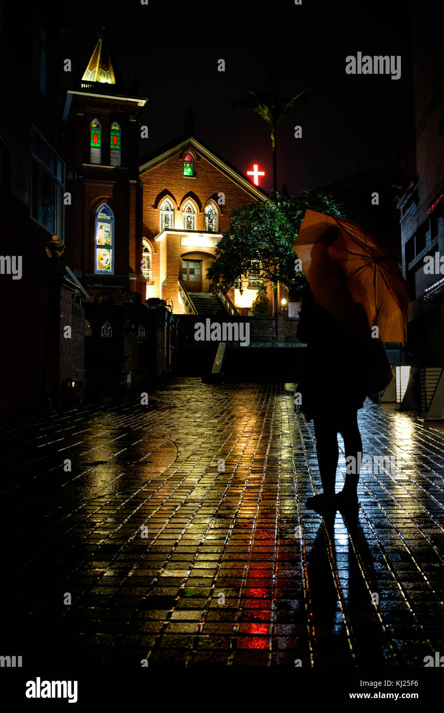 A woman stands in front of a church in a rainy day in Taiwan Stock ...