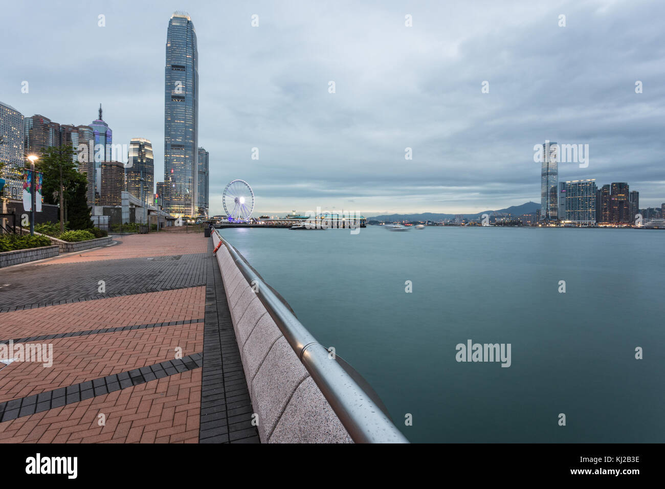 Sunset over the Victoria harbor waterfront promenade in Hong Kong ...