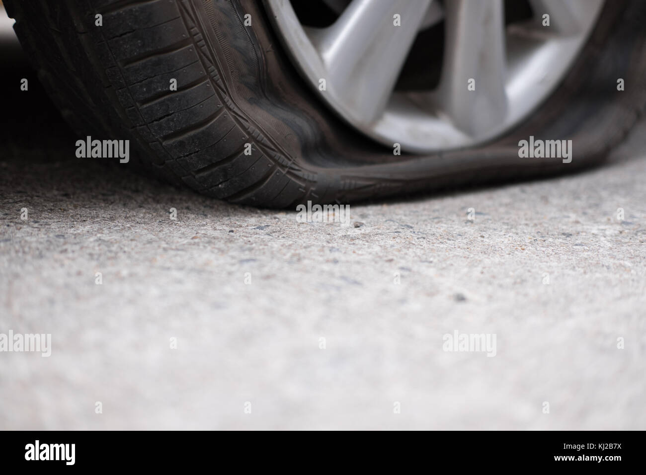 Car tire leak because of nail pounding. flat tyre on road. Flatten ...
