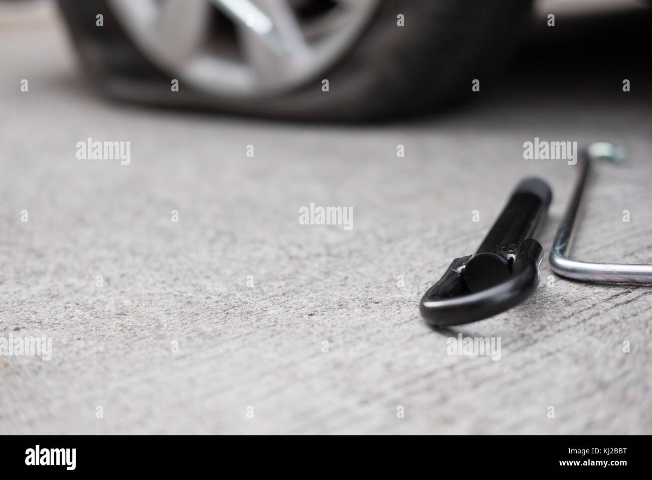 Car tire leak because of nail pounding. flat tyre on road. Flatten ...