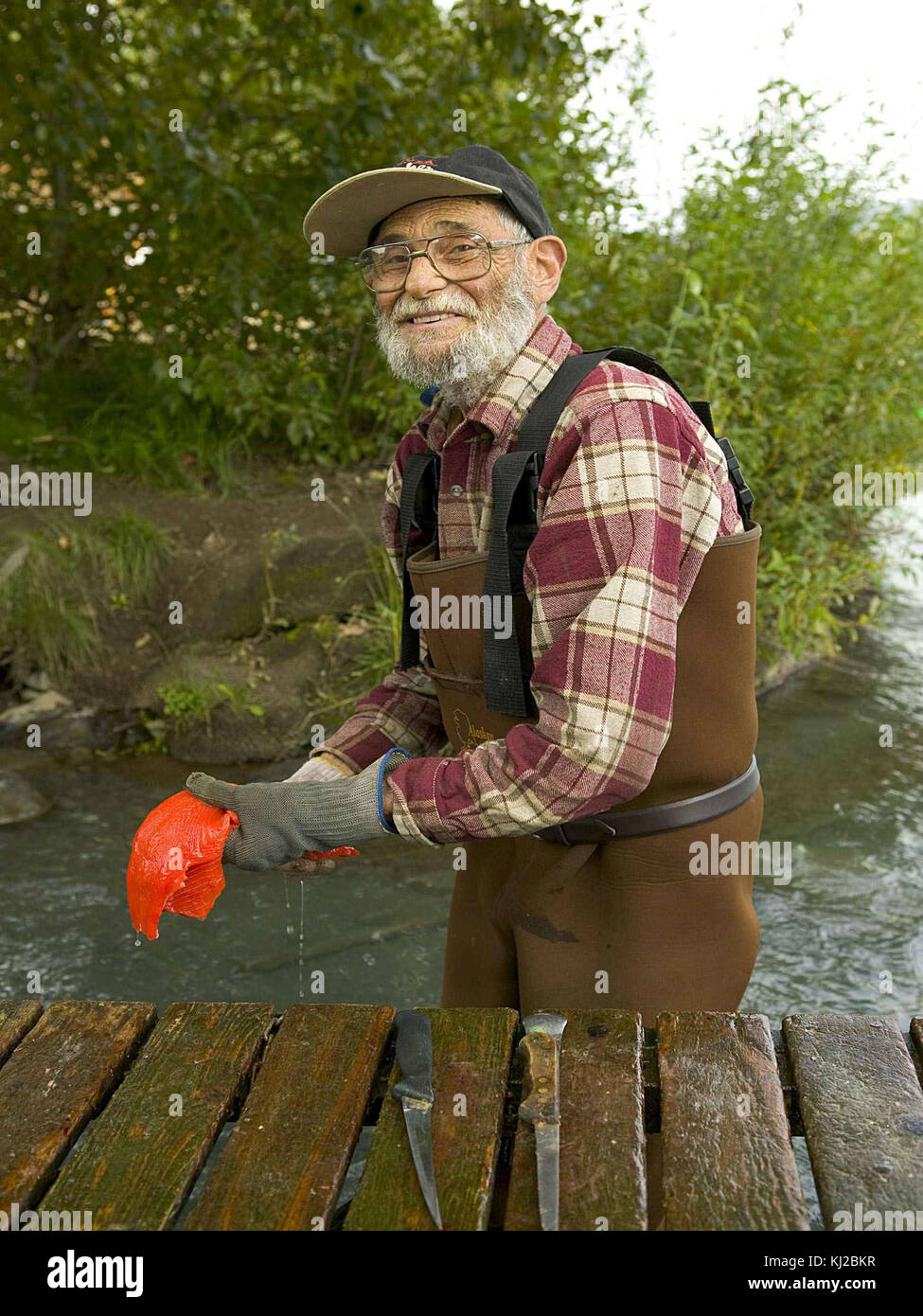Old man fisherman cleans fish Stock Photo - Alamy