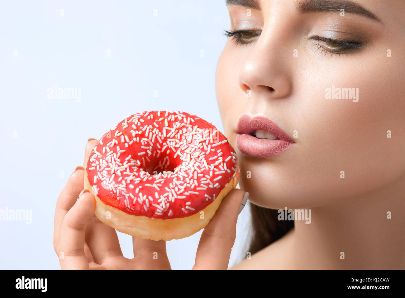 beautiful woman biting a donut Stock Photo - Alamy