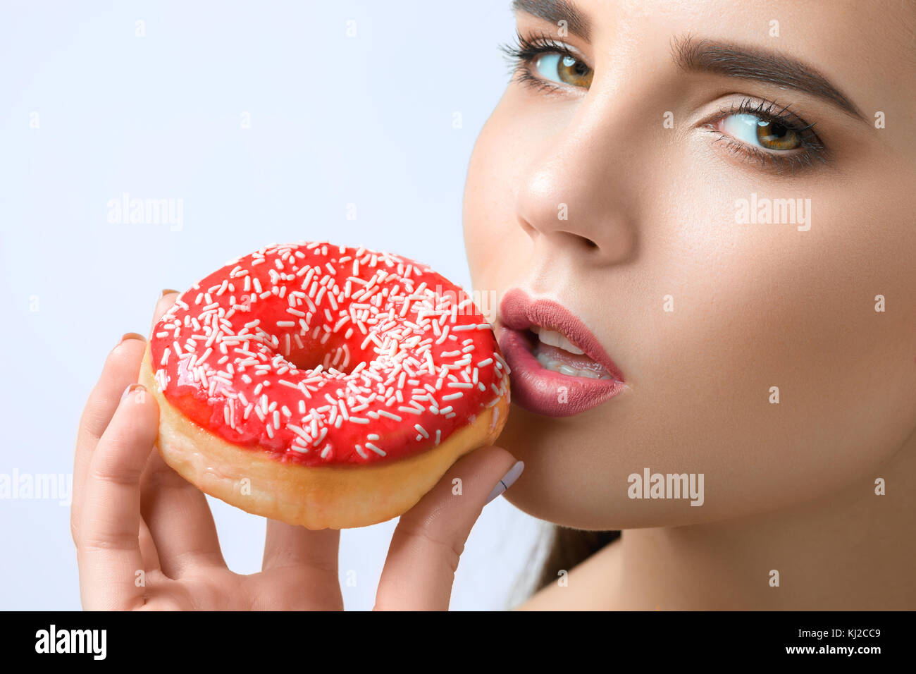 beautiful woman biting a donut Stock Photo - Alamy