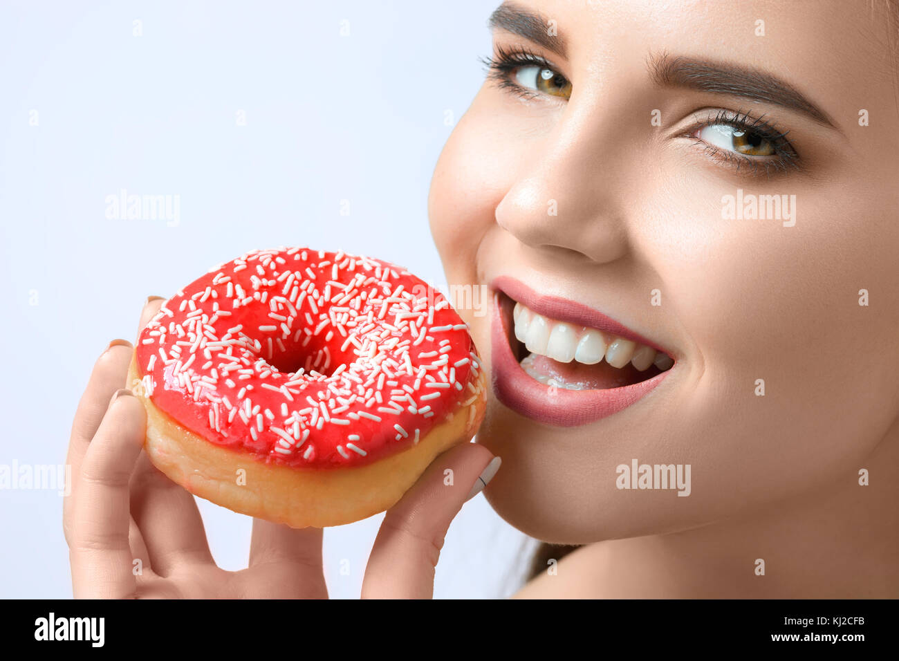 beautiful woman biting a donut Stock Photo - Alamy