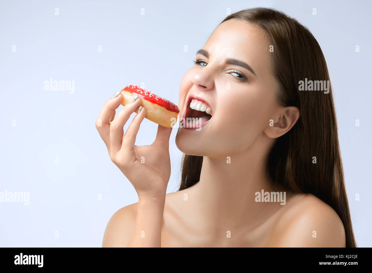 beautiful woman biting a donut Stock Photo - Alamy