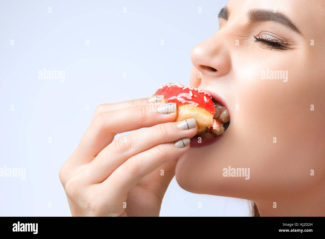 beautiful woman biting a donut Stock Photo - Alamy