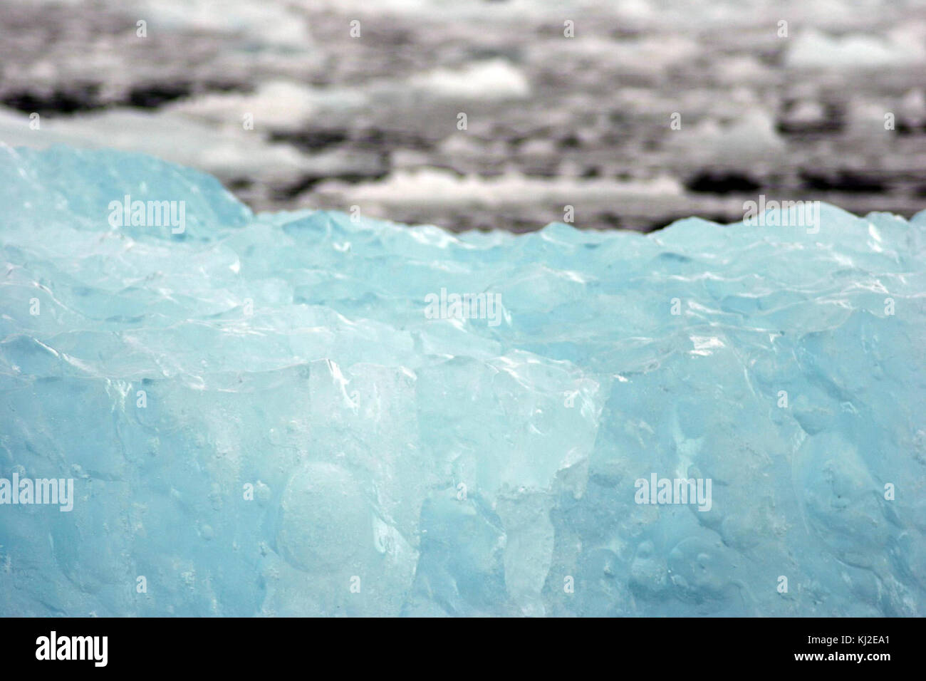 This photograph captures a blue iceberg floating in open waters ...