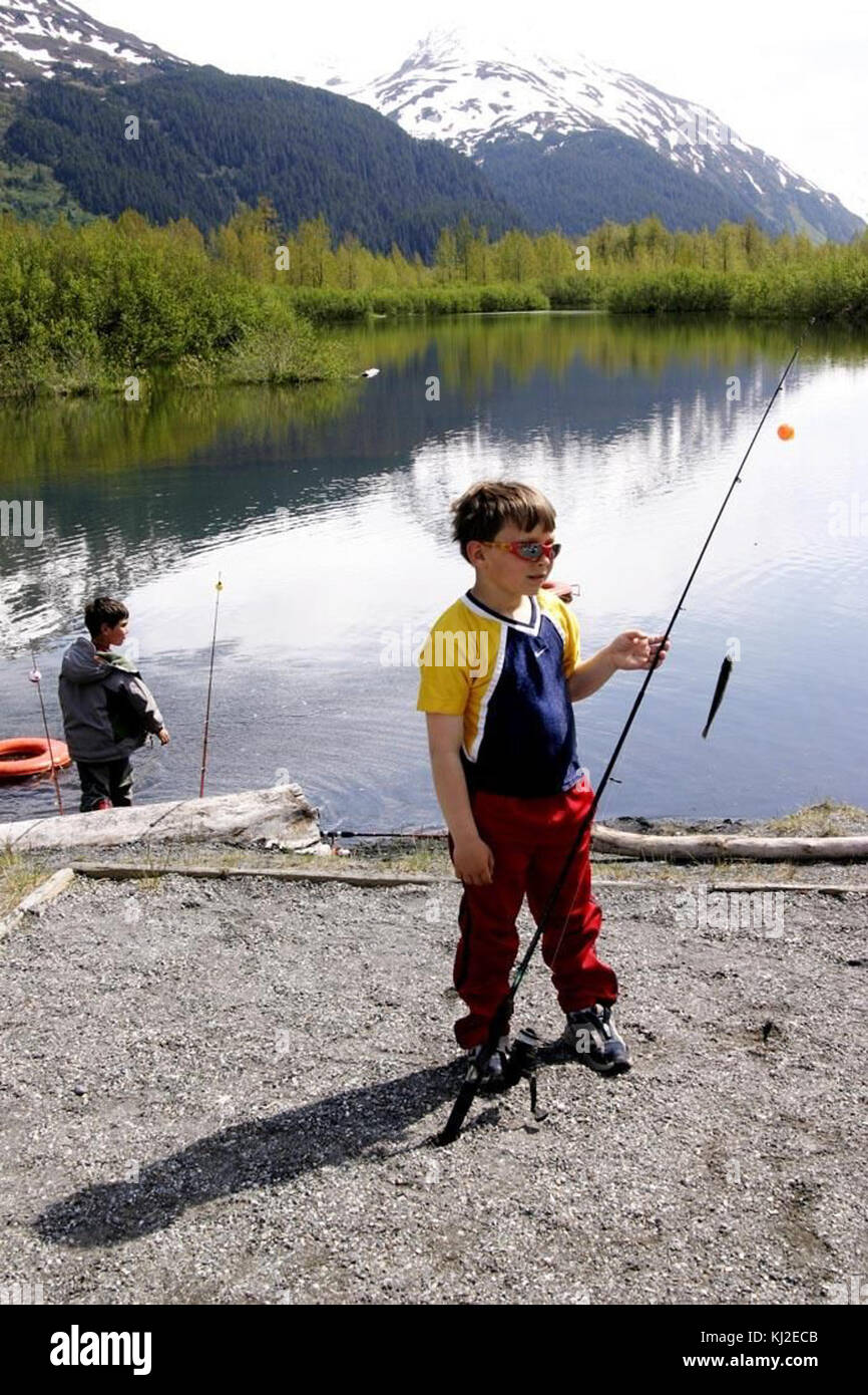 Boy with fishing pole and a small fish Stock Photo - Alamy