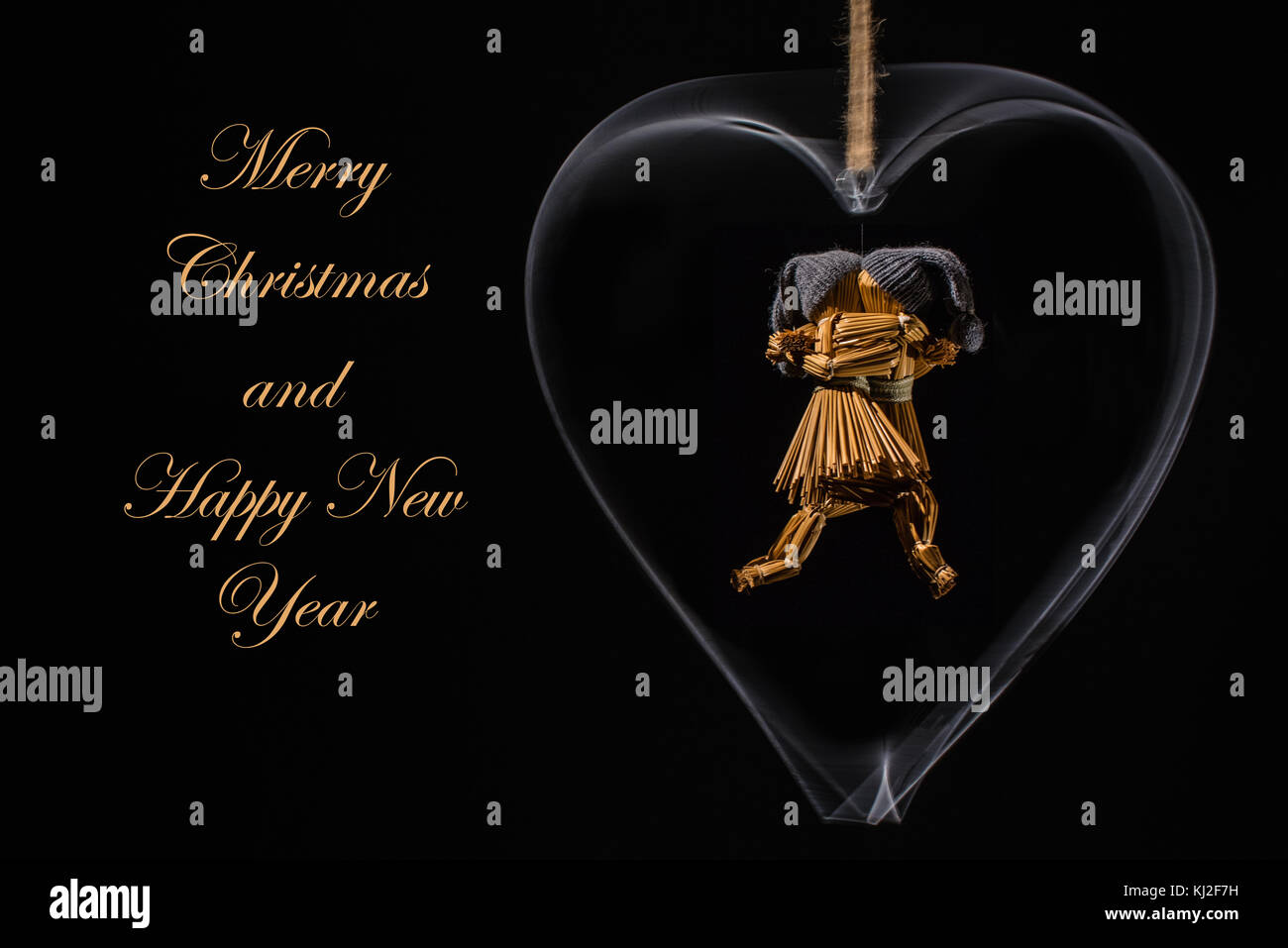 Christmas greetings with dancing straw dolls in a rotating metal heart ...