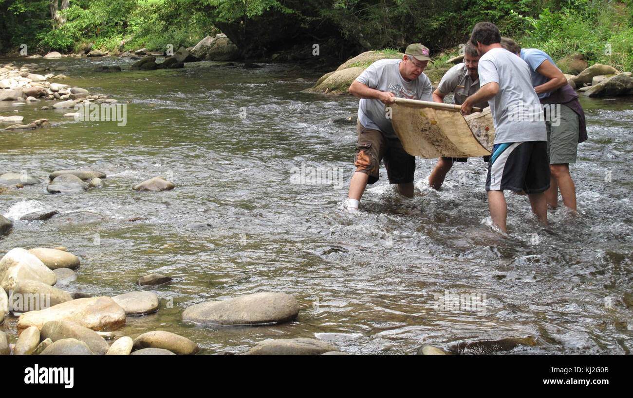People standing in water and keep a blanket used as a sieve Stock Photo ...