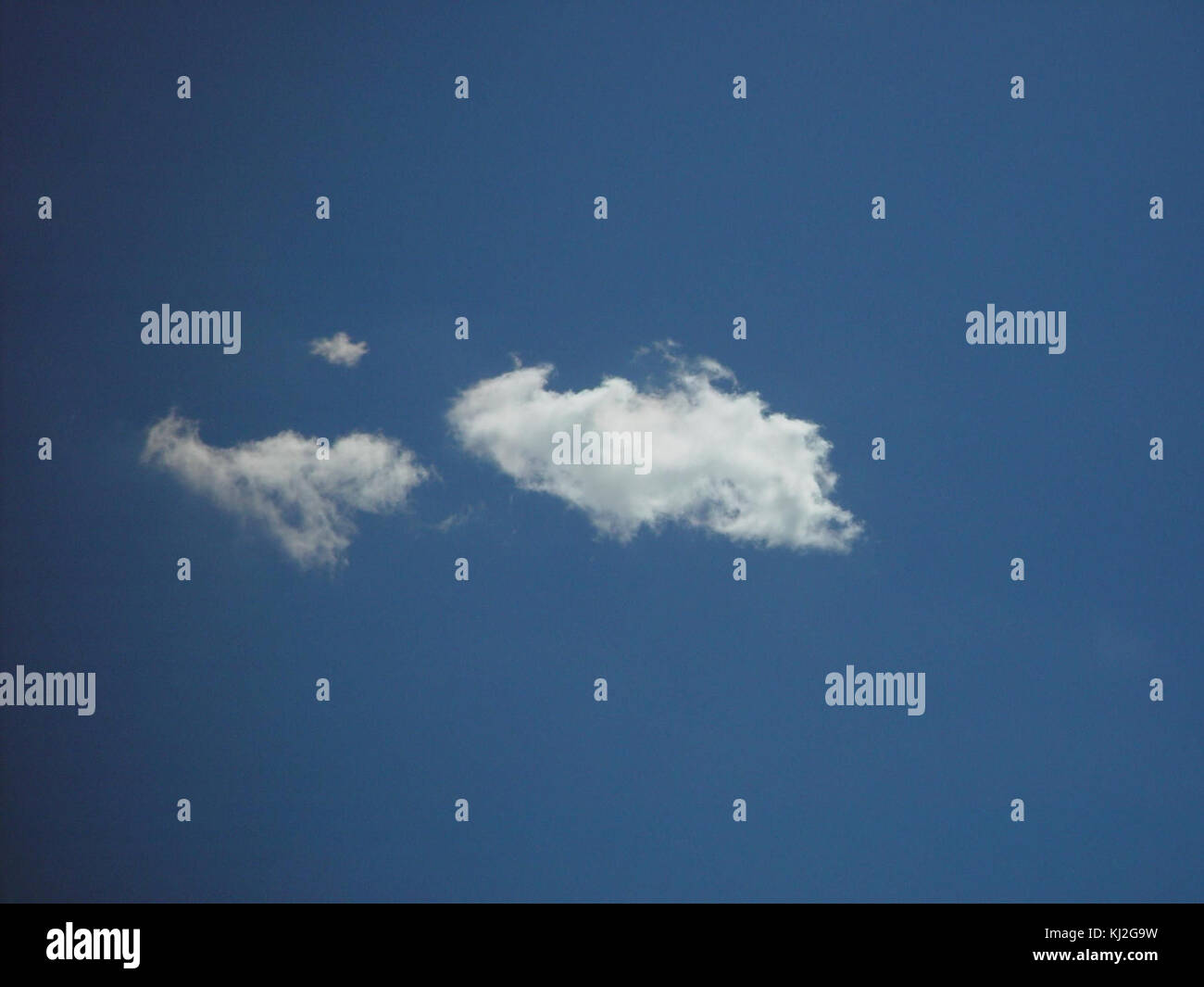 The image depicts a fluffy white cloud set against a clear, deep blue ...