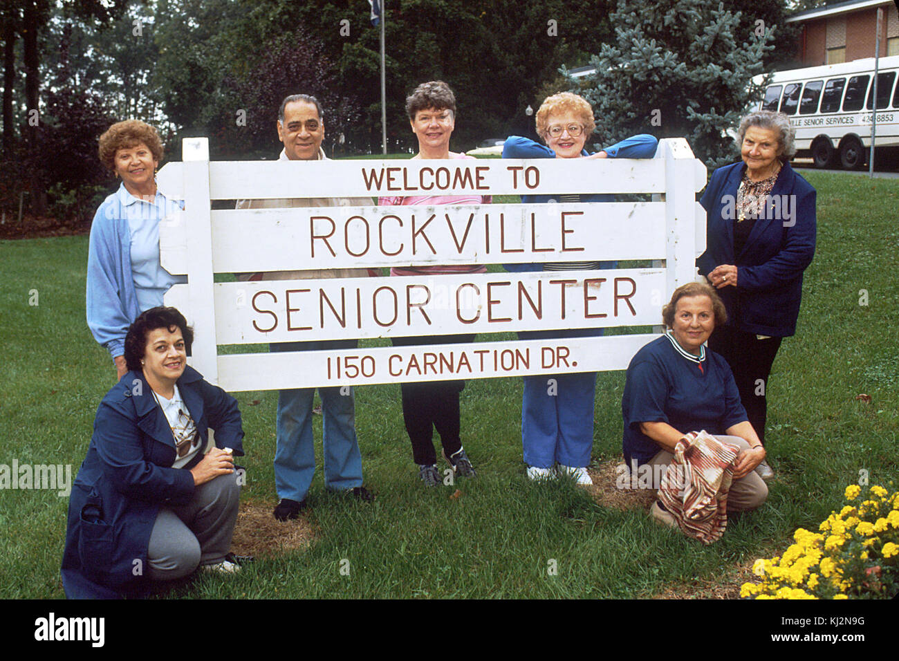 Senior citizens gathered around sign Stock Photo - Alamy