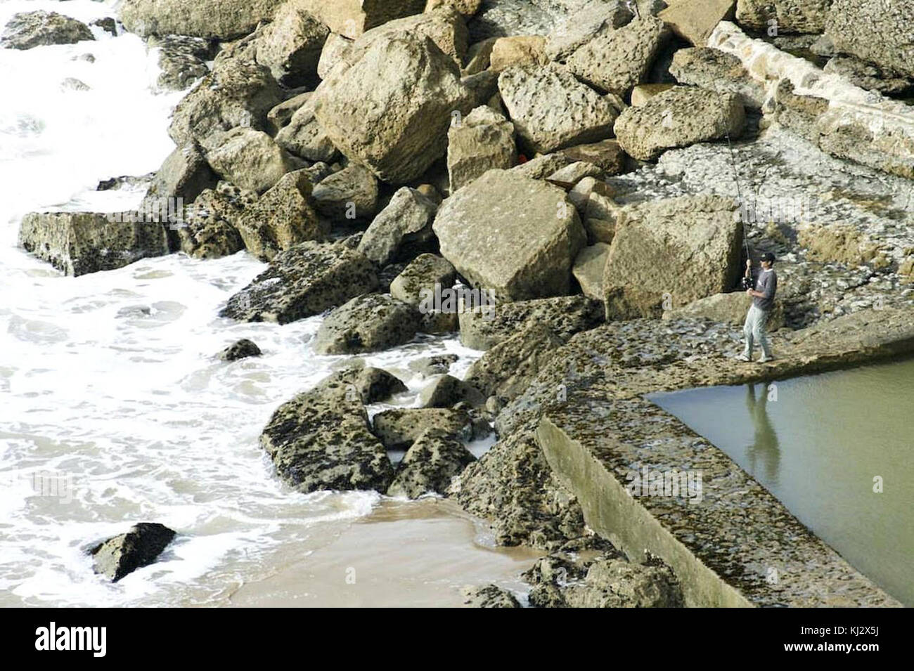 Fisherman fishing on see under waves Stock Photo - Alamy
