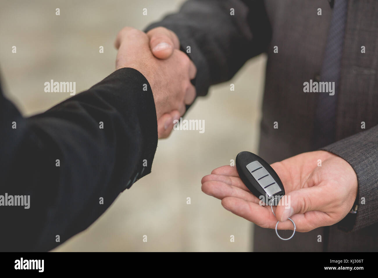 Vehicle dealer passing keys from new car to happy young man Stock Photo ...