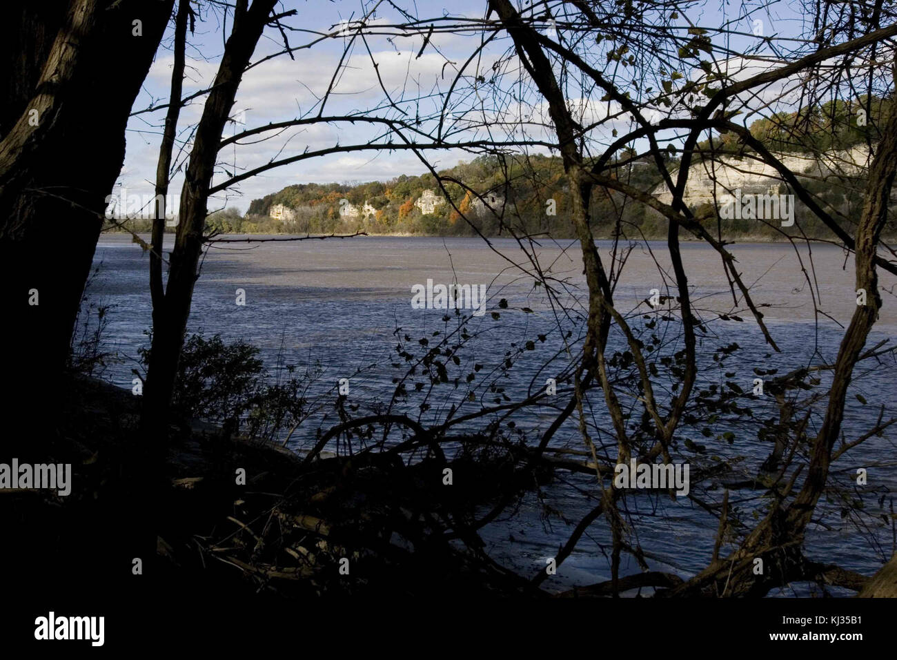 Sunlit limestone cliffs on far side of the missouri river viewed ...