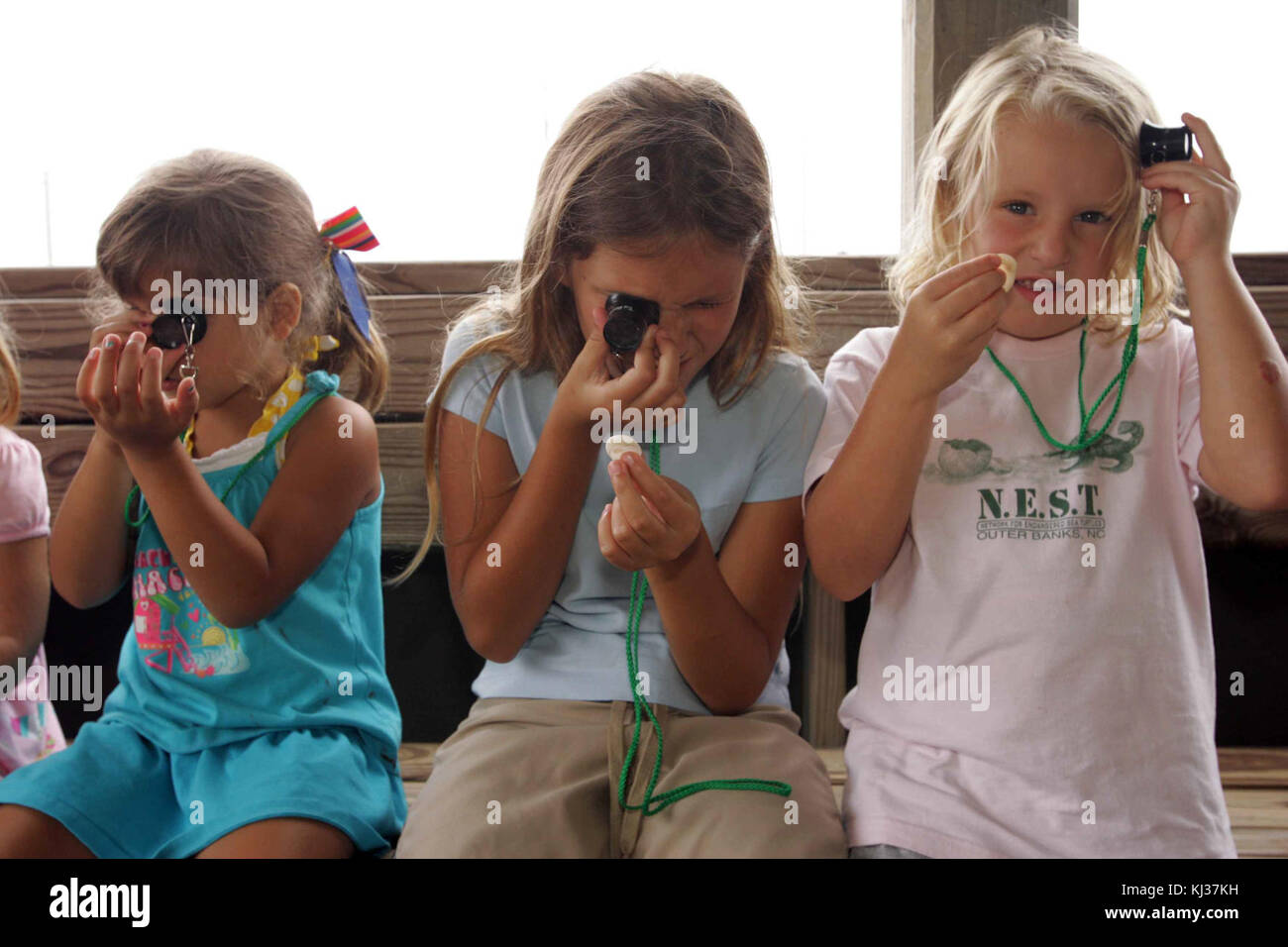 Three cute blonde girls are sitting on the bench Stock Photo - Alamy