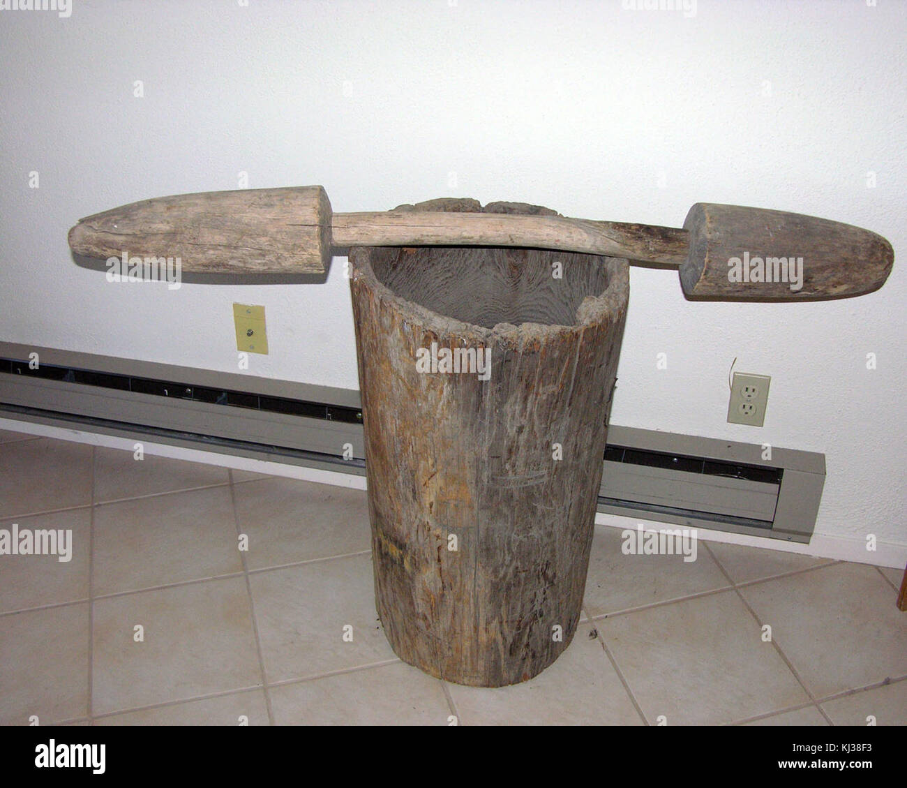 This image shows a traditional wooden rice mortar, an essential tool in ...