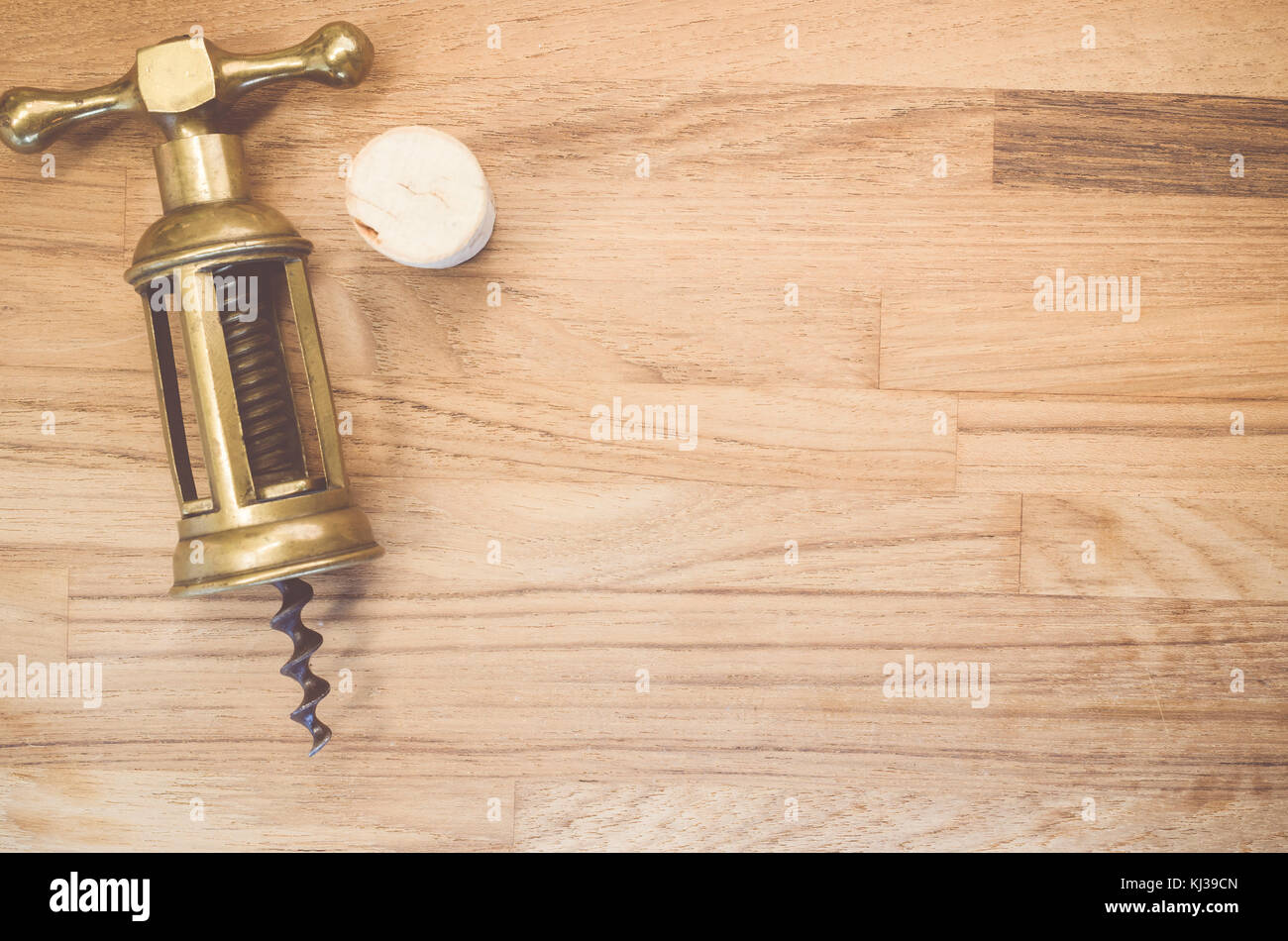 vintage hand made solid brass corkscrew and cork on a natural wood ...