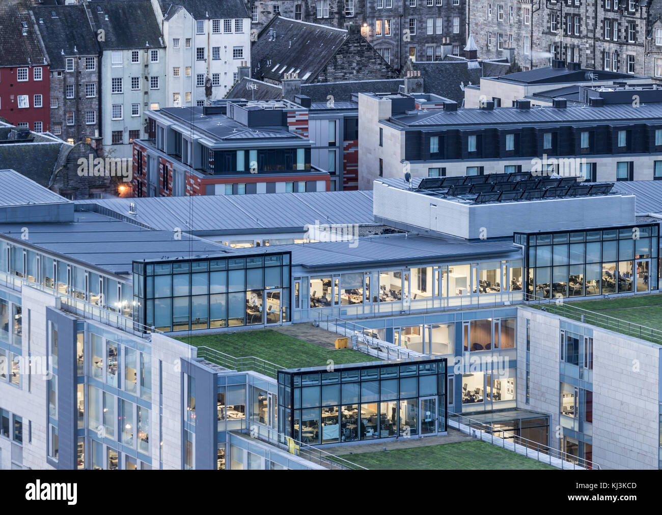 View over modern office building with lights on alongside older ...