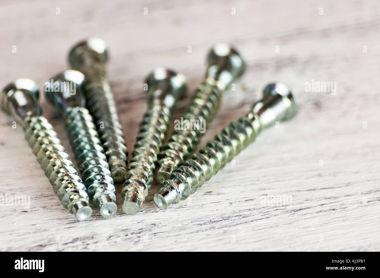 Several long screws lie on a light background. Macro photo Stock Photo ...