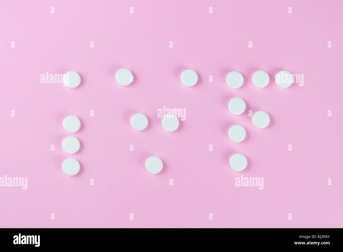 The word IVF, written on a pink background with white tablets ...