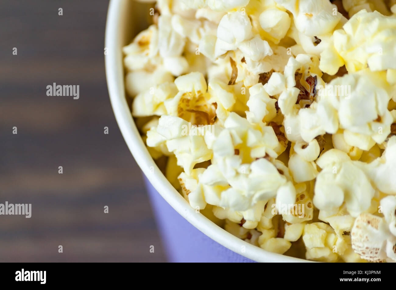 Popcorn in a bucket bucket is a top view on a dark wooden background ...