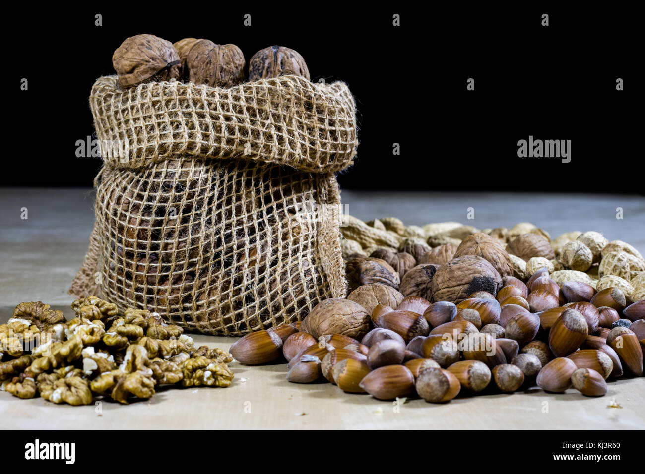 Fresh nuts in a jute bag on a wooden kitchen table. Italian hazelnuts ...
