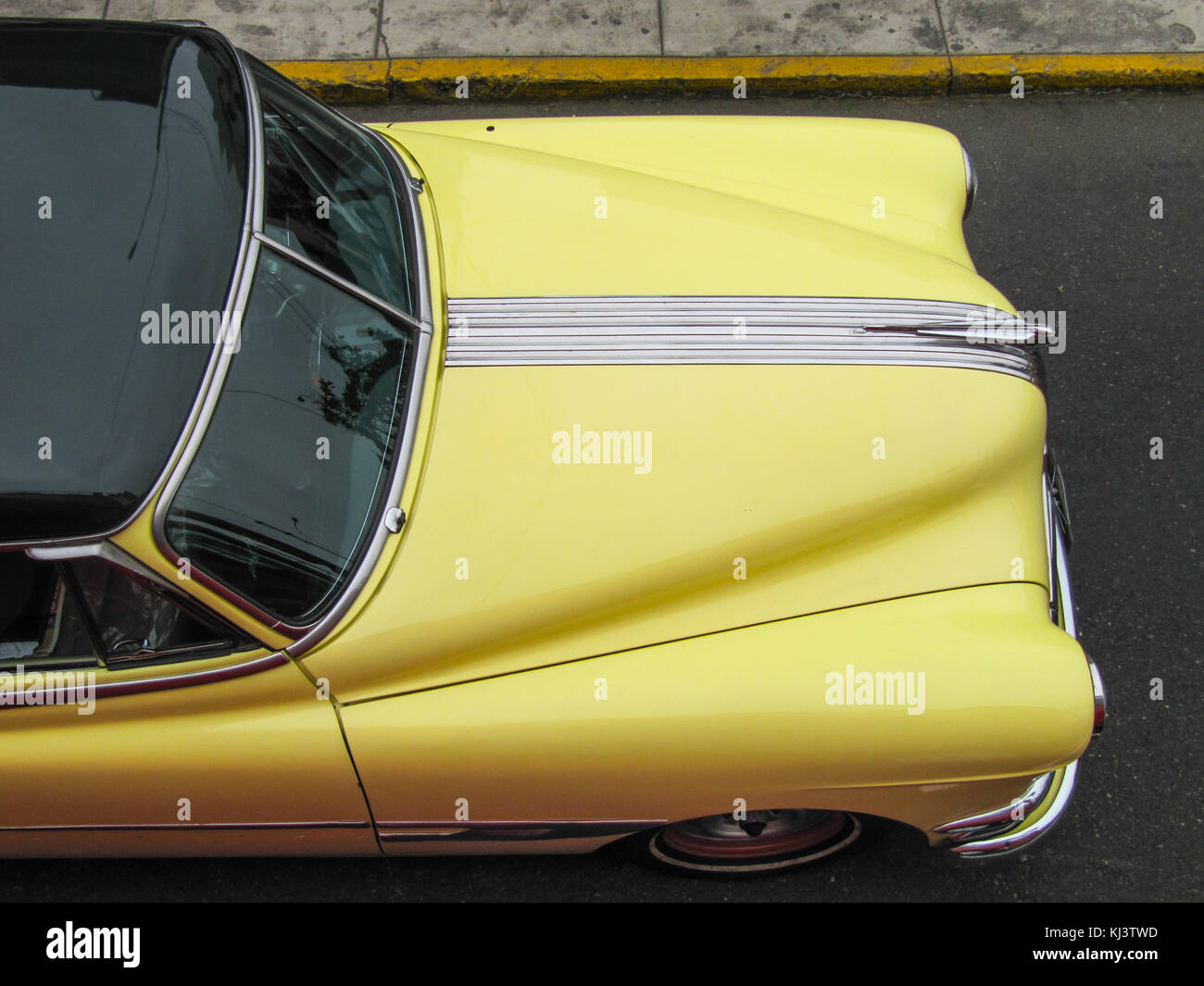 Classic vintage car from above on roadside. Restored elegant yellow and ...