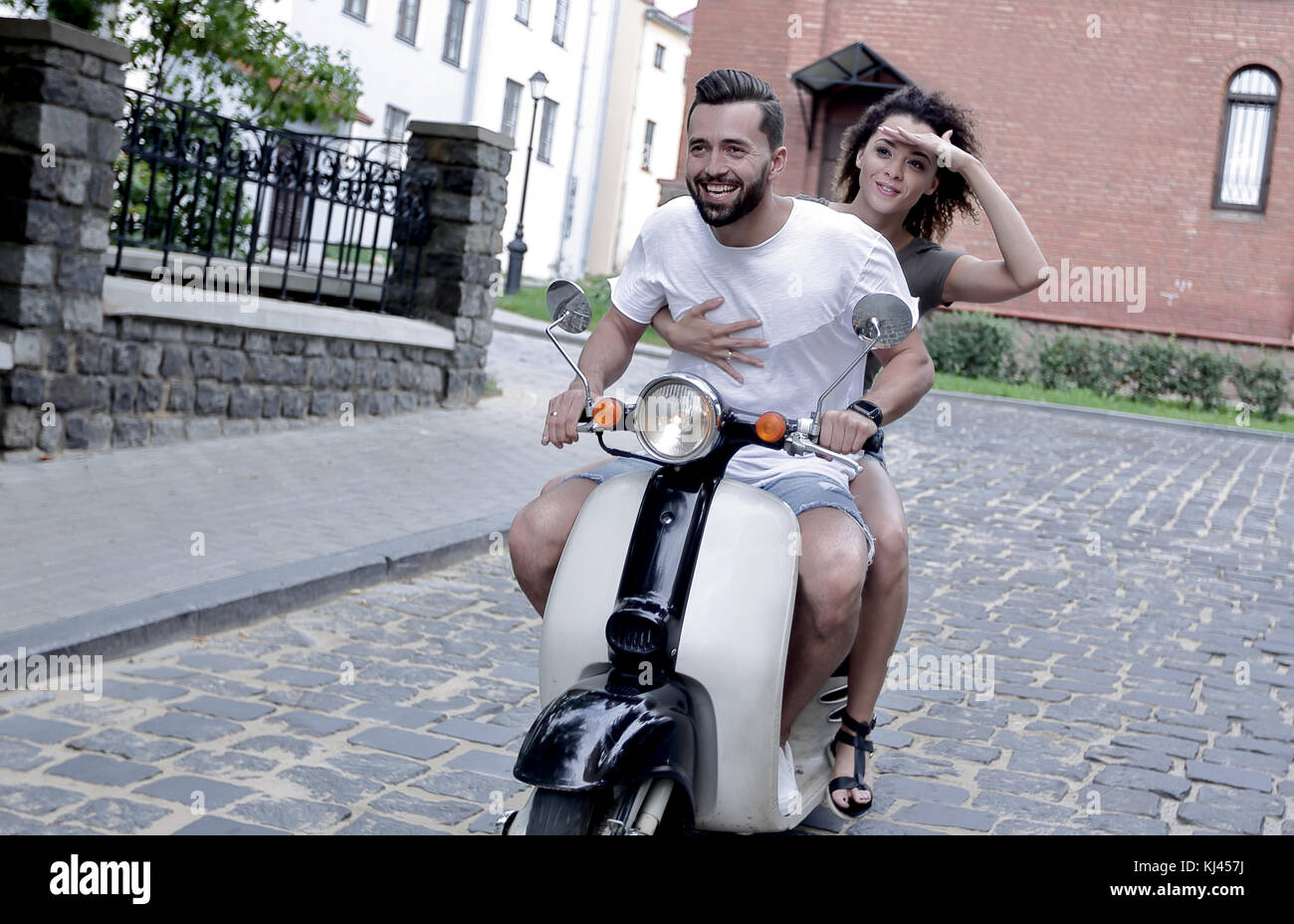 Young couple riding motor scooter in city Stock Photo - Alamy