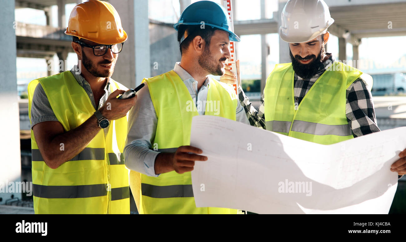 Team of construction engineers working on building site Stock Photo - Alamy