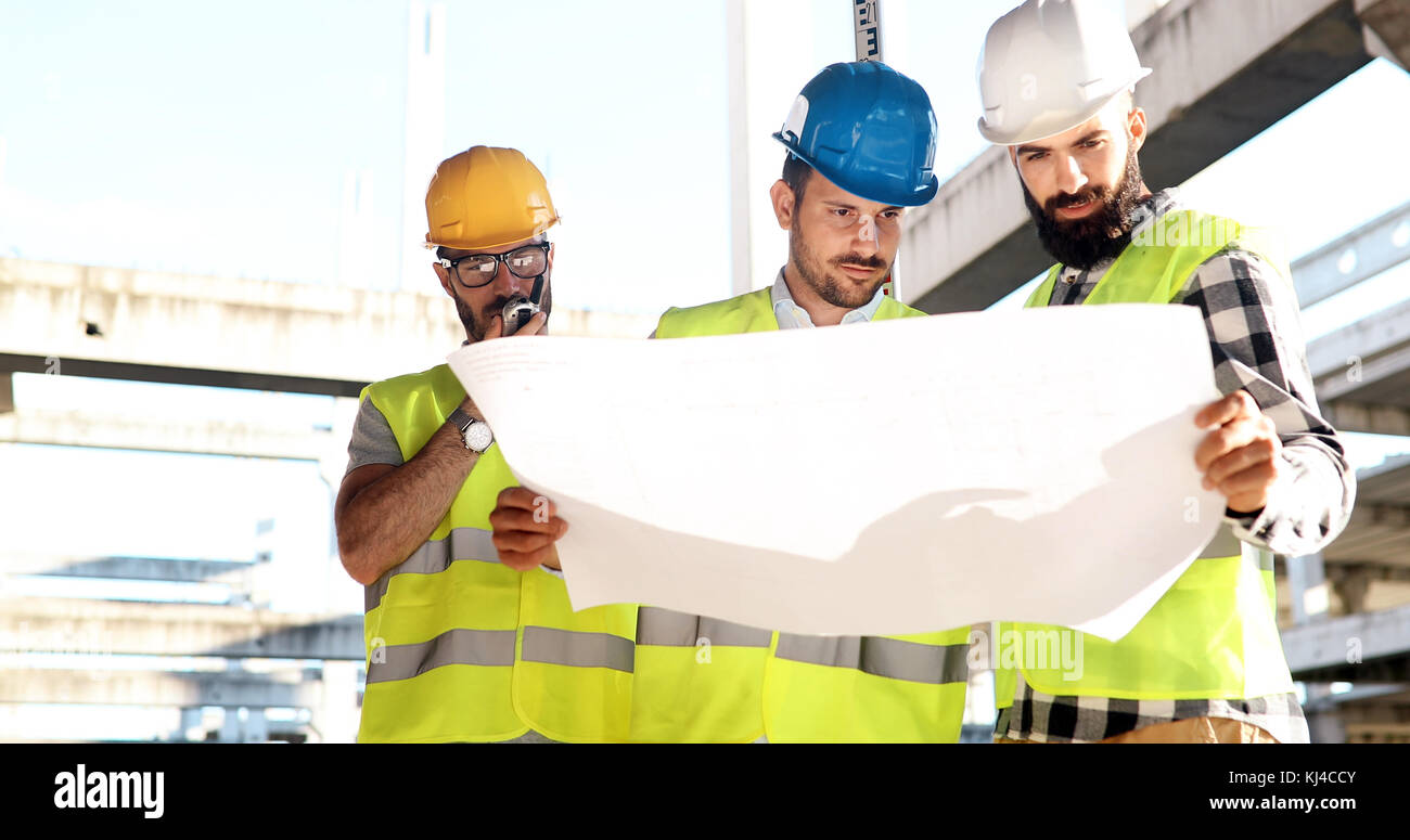 Construction engineers discussion with architects at construction site ...