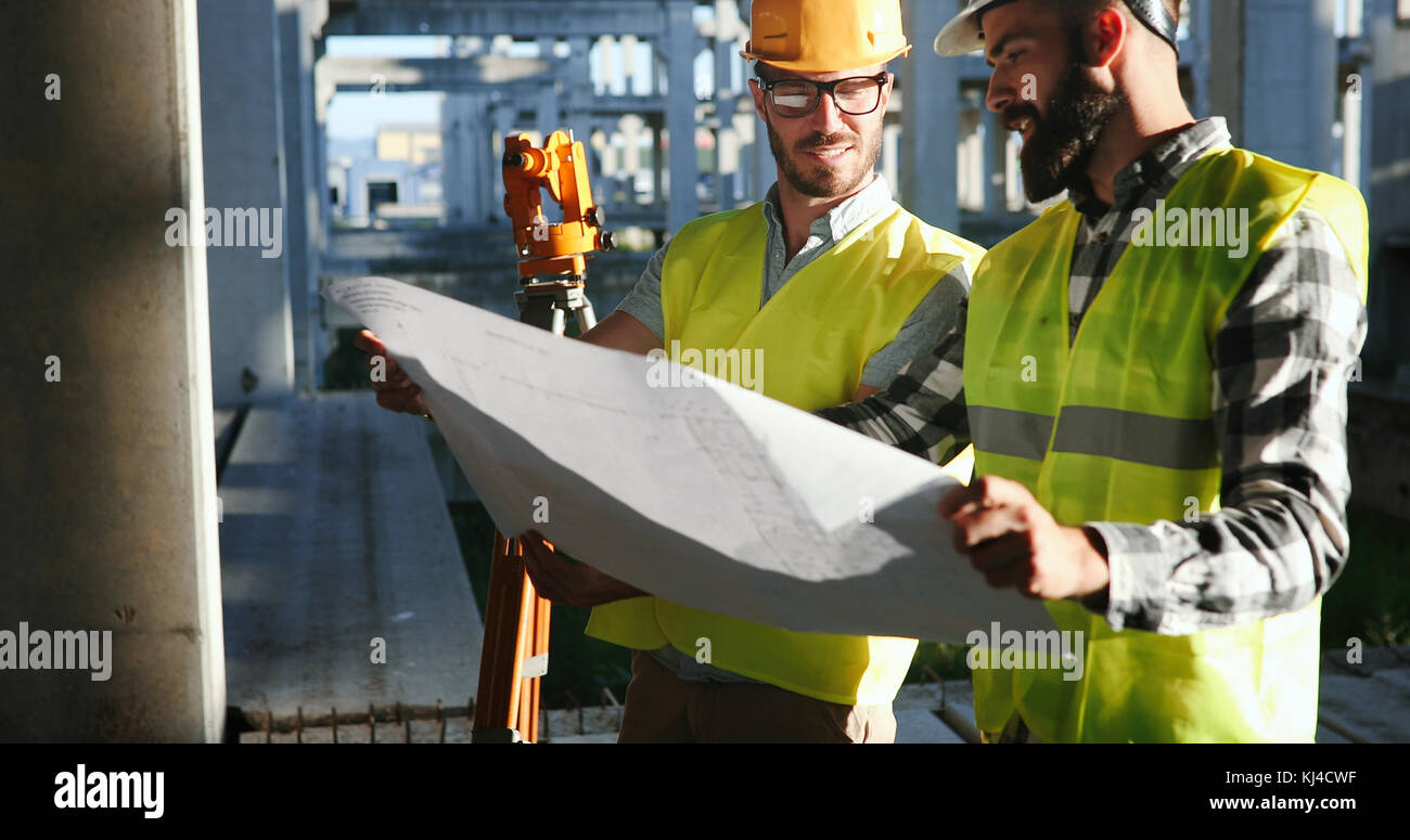 Team of construction engineers working on building site Stock Photo - Alamy