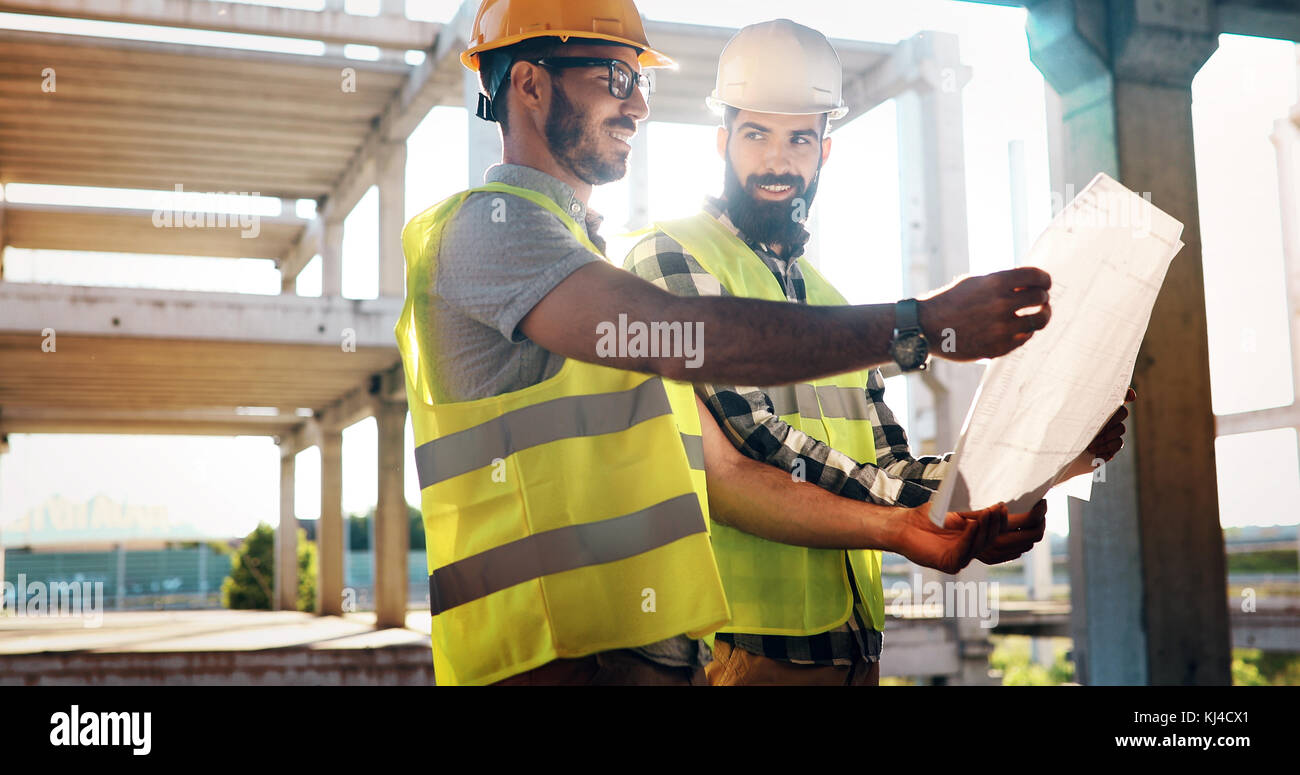 Construction engineers discussion with architects at construction site ...