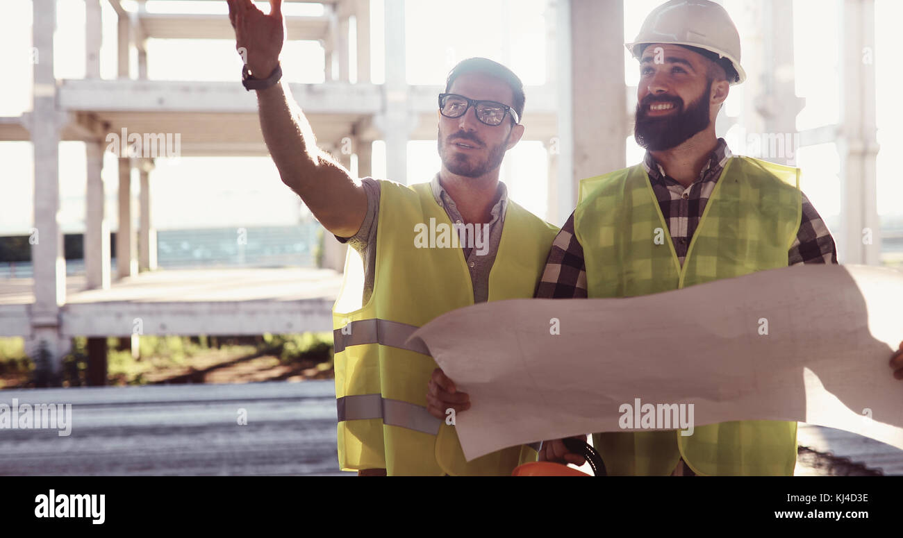 Construction engineers discussion with architects at construction site ...